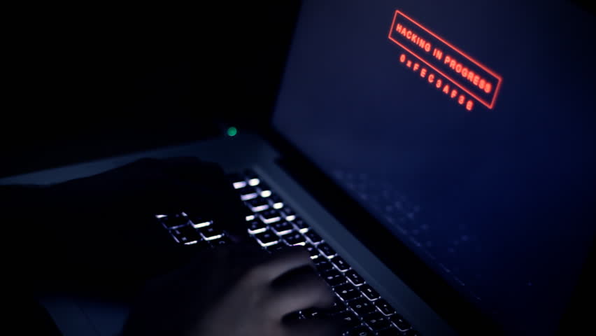 Hacker Typing On Keyboard With A Program In The Background Stock
