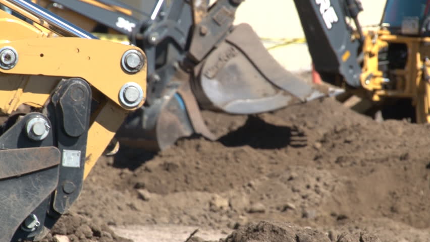 Backhoes Digging And Dumping Foreground And Background While Excavating ...