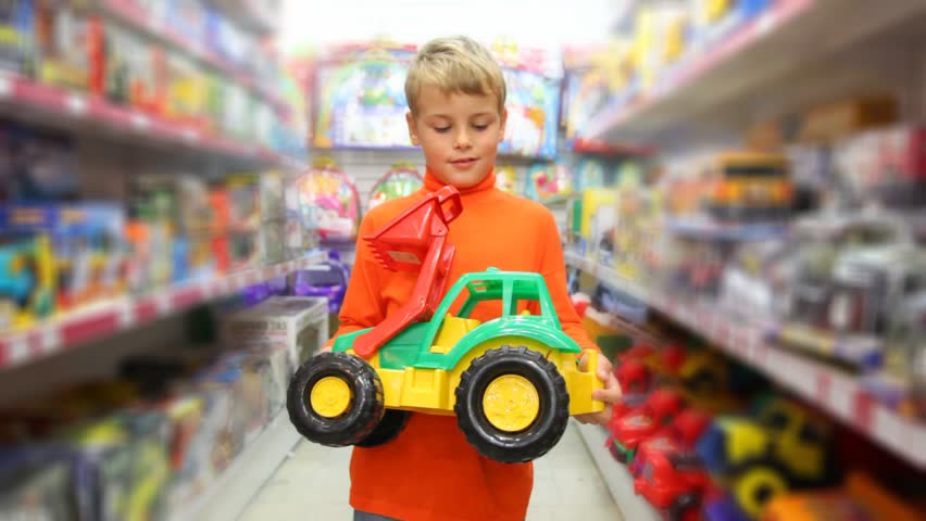 Happy Boy Examines Toy Excavator In Toy Store Stock Footage Video ...